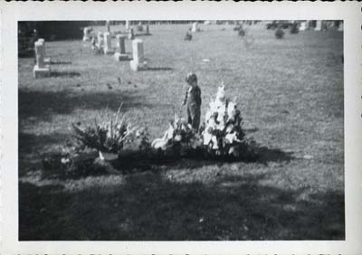 Photograph, child standing over grave - Rochester Voices